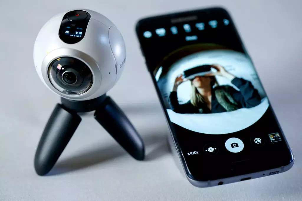 Työntekijä osoittaa aiemmin julkaistun Samsung Electronics Co. Vaihde VR, näkyvissä Samsung Galaxy S7 -reunassa, jossa 3D Thermo muodostavat, aivan uuden Samsung Gear 360: n, videokameran, vasemmanpuoleisen videokameran rinnalla, joka lähettää 360 asteen videosta mobiililaitteeseen Lontoossa, Yhdistyneessä kuningaskunnassa, torstaina, 2. helmikuuta 18 Kuvaajalla: Luke MacGregor / Bloomberg